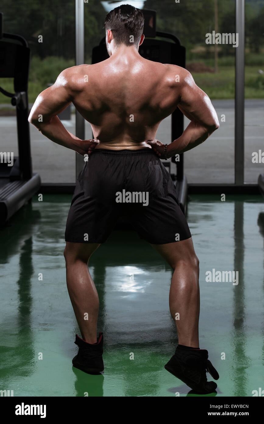 Serious Man Bodybuilder Standing In The Gym And Flexing Muscles Stock ...