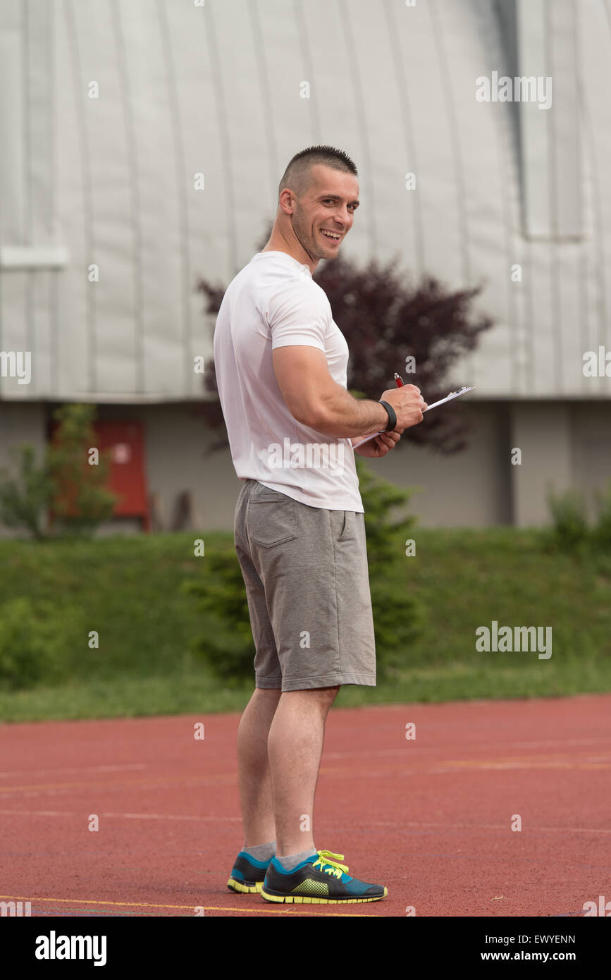 Portrait Of A Male Fitness Instructor Holding Clipboard Outdoor Stock ...