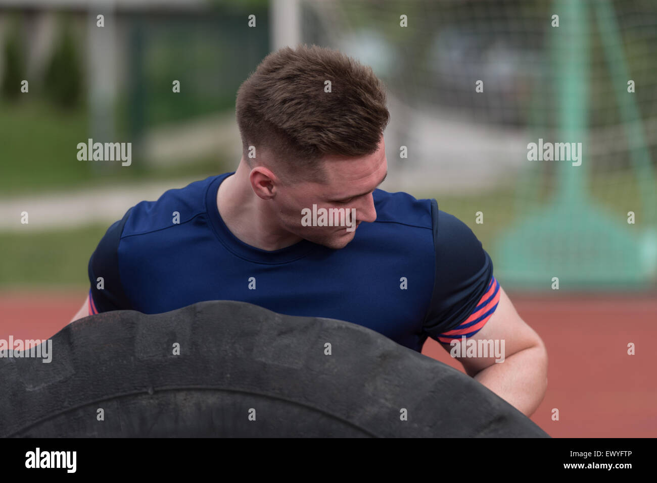 Young Man Turning Tire Over - Bodybuilding Exercises Truck Tire Stock ...