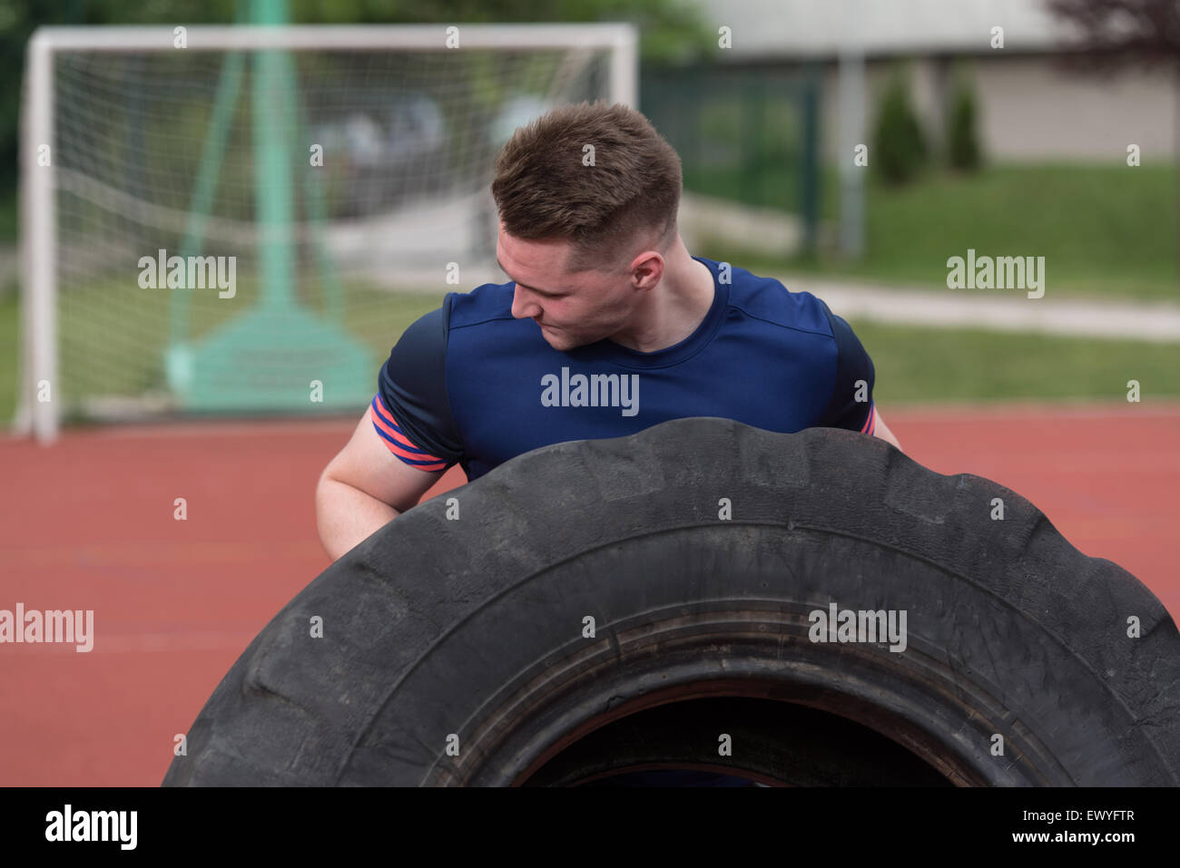 Young Man Turning Tire Over - Bodybuilding Exercises Truck Tire Stock ...