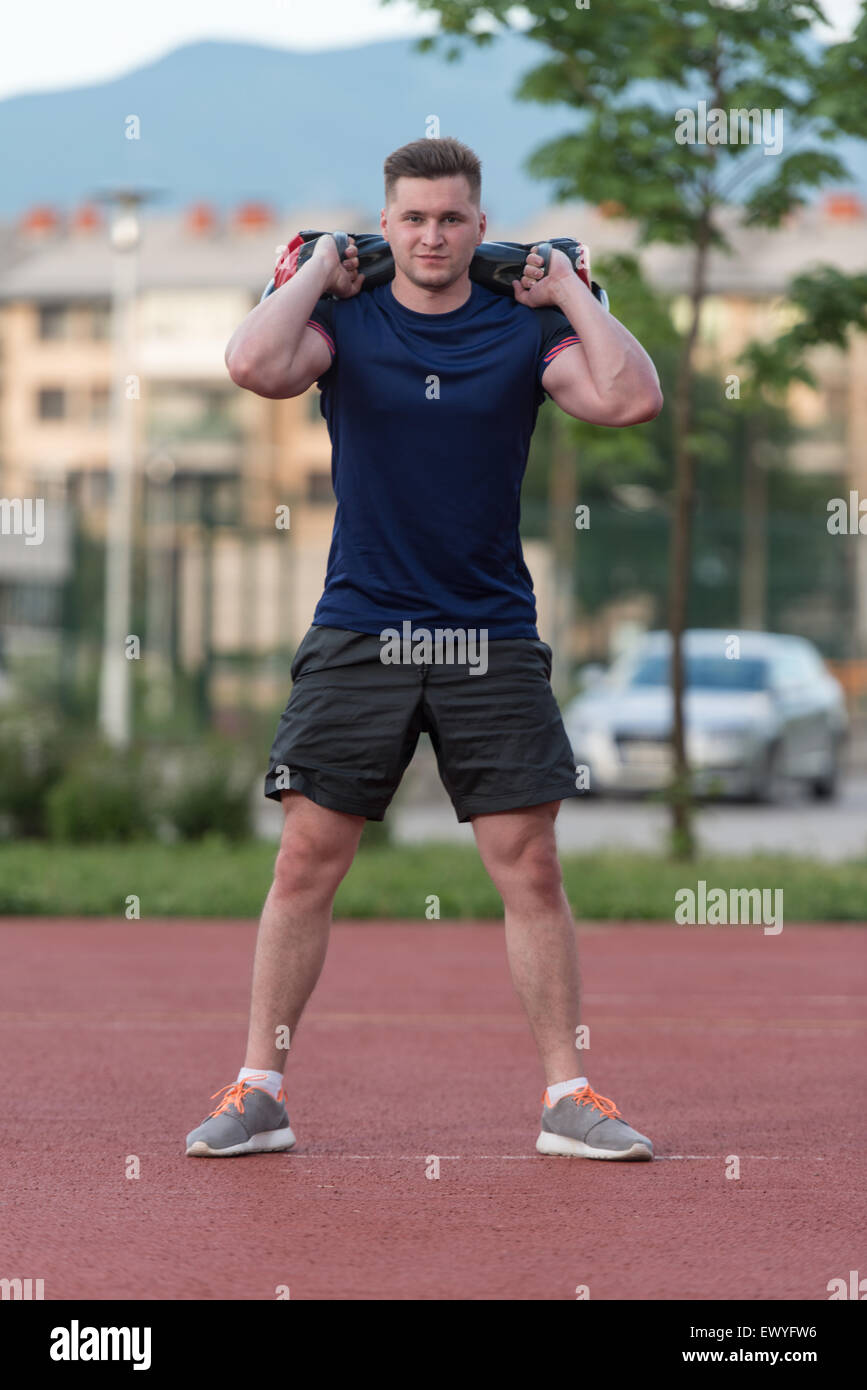 Young Man Performing Bag Squat Exercise Outdoor Stock Photo - Alamy