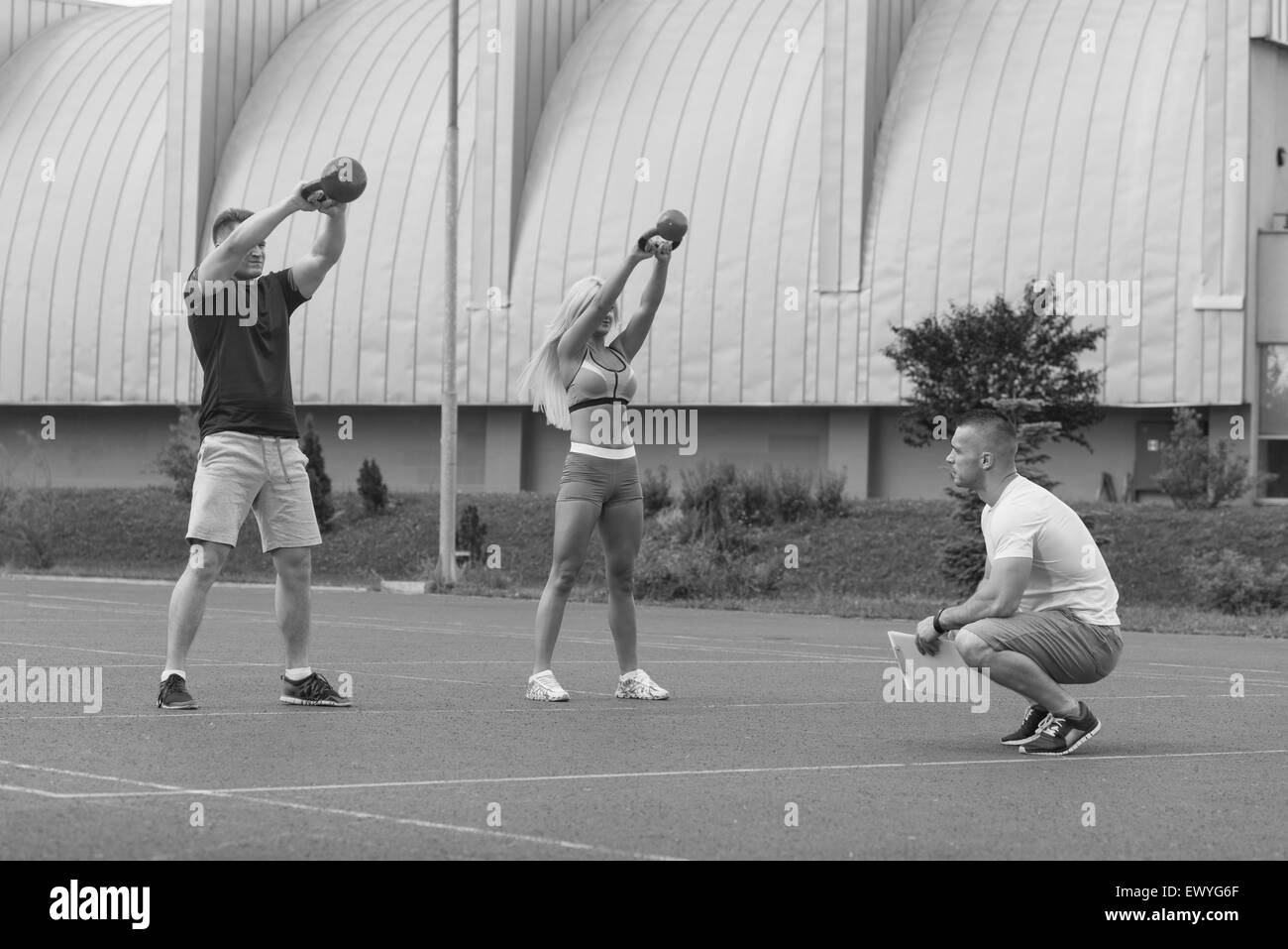 Group Of Young People Doing A Kettle Bell Exercise Outdoor With ...