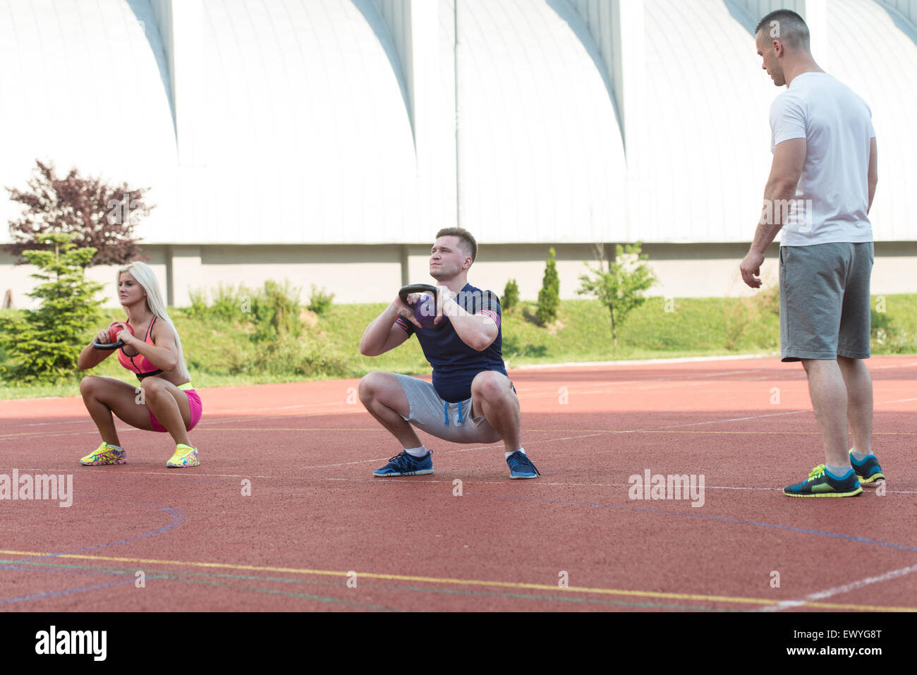Group Of Young People Doing A Kettle Bell Exercise Outdoor With ...