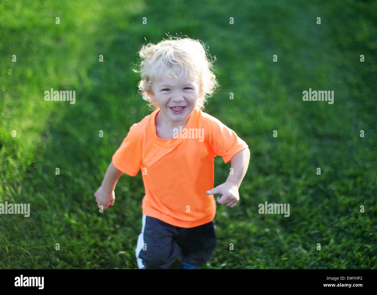 Smiling boy running outdoors Stock Photo - Alamy