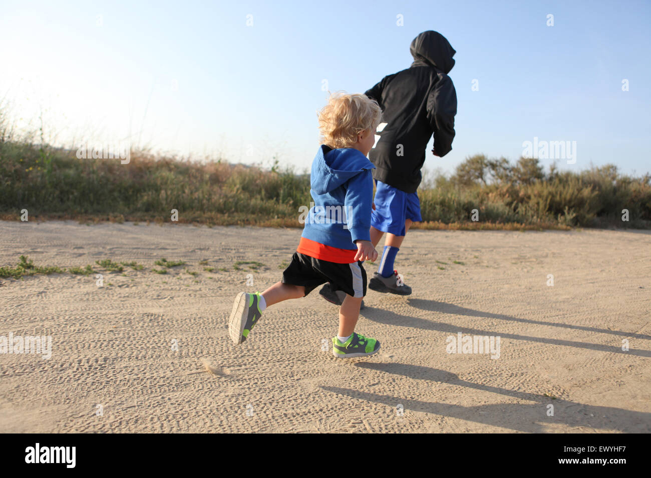 Rear view of two boys running Stock Photo - Alamy