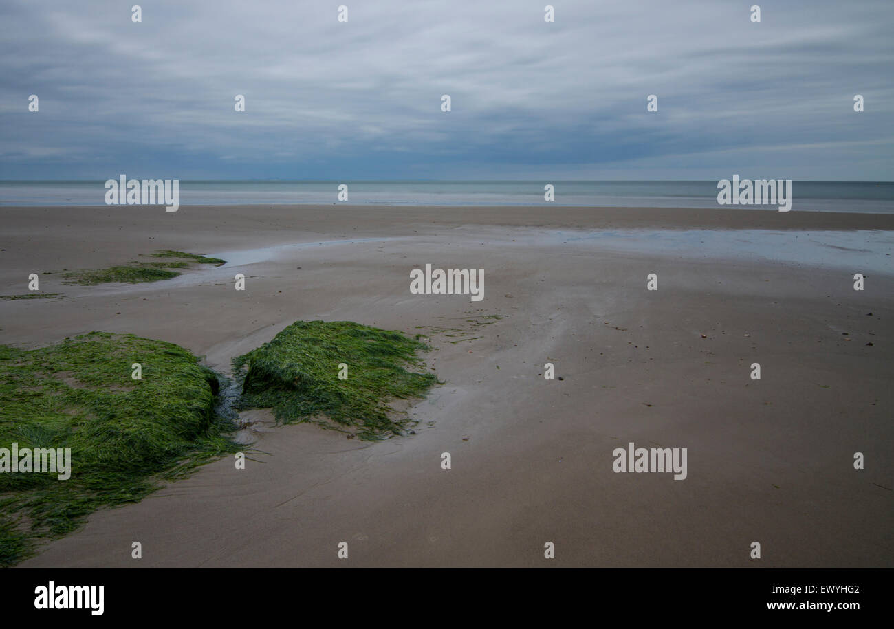 tide out on quiet beach and rocks Stock Photo - Alamy