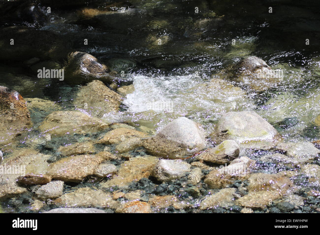Clear water stream running over submerged rocks ideal background or ...