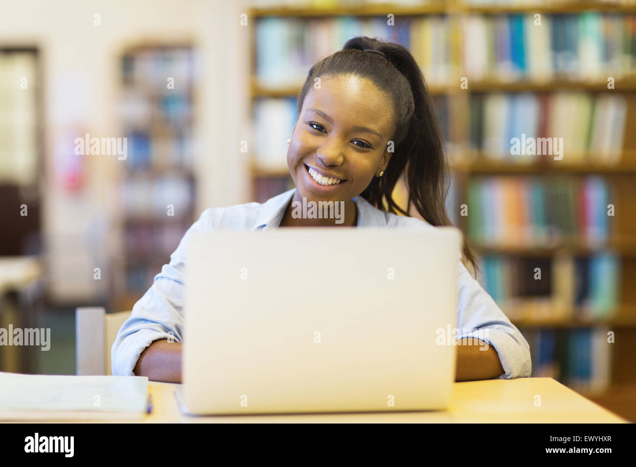 African American university student using laptop computer in library ...