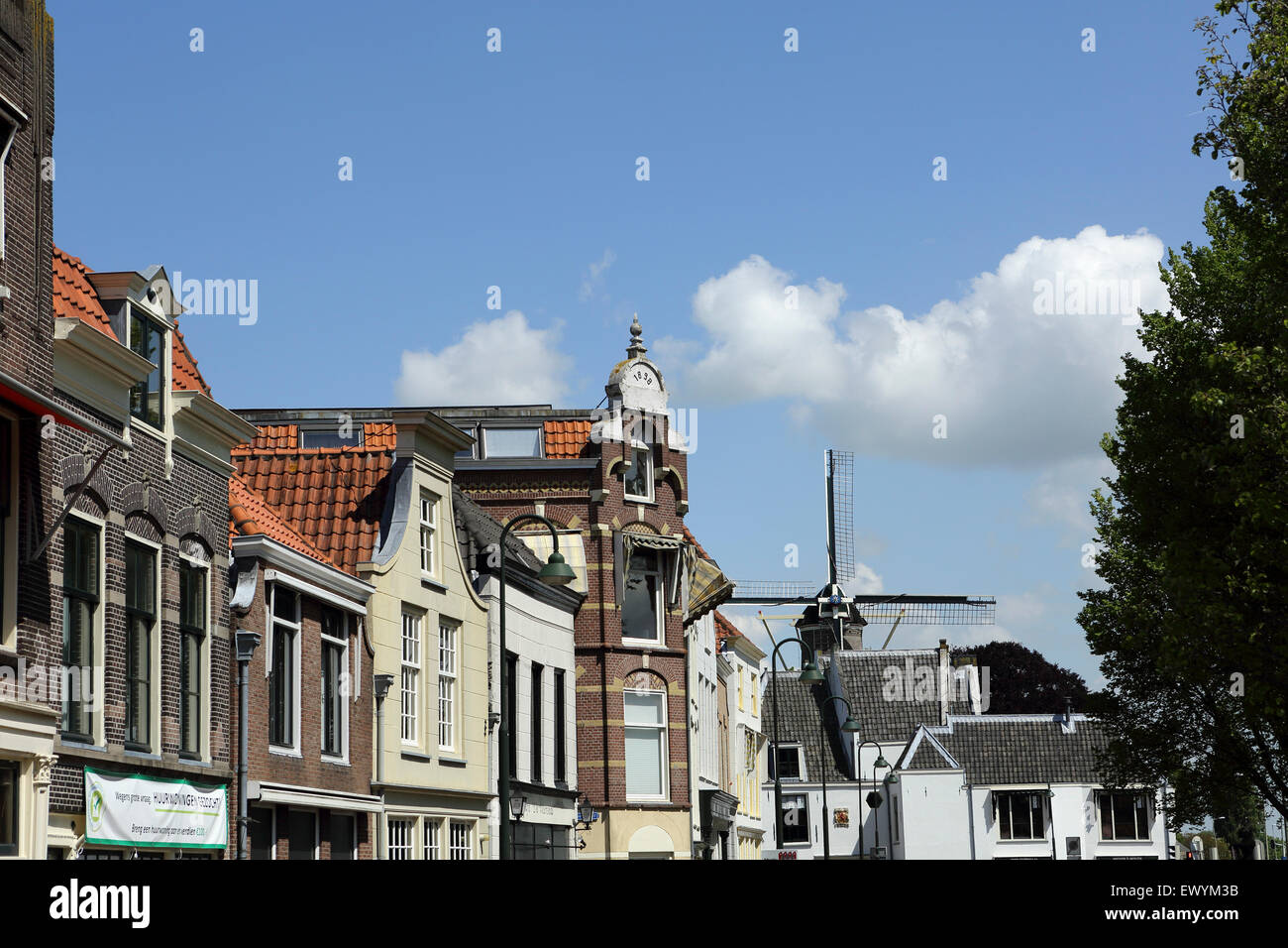 Traditional Dutch facades in Gouda, the Netherlands. A windmill stands ...