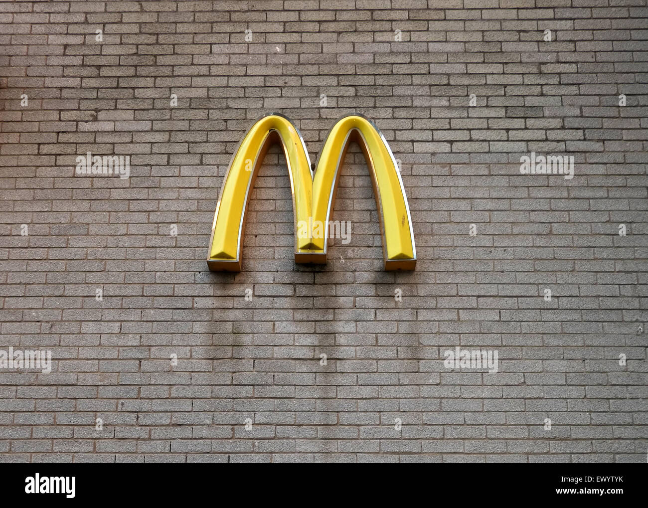 Yellow M Mcdonald's sign on a plain brick wall, it's it a service yard ...