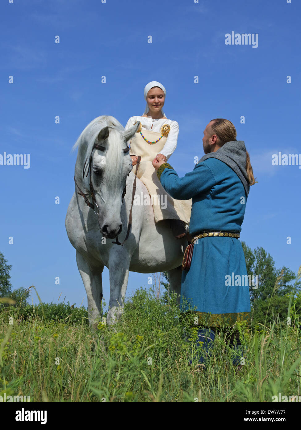 Married couple dressed in clothes of the Vikings with a horse bareback ...