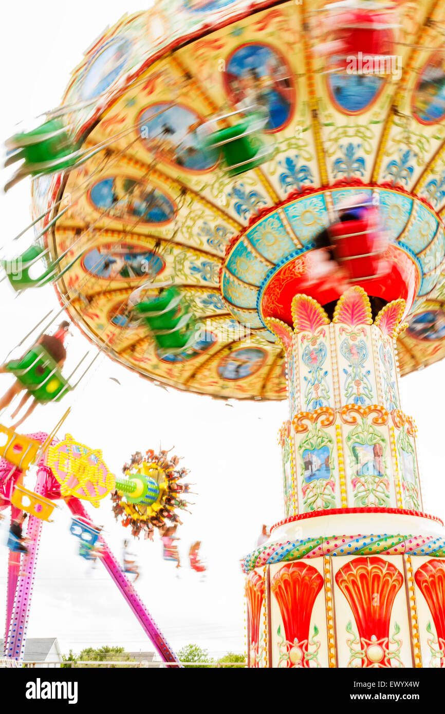Children riding a colorful merry-go-round at the county fair Stock ...