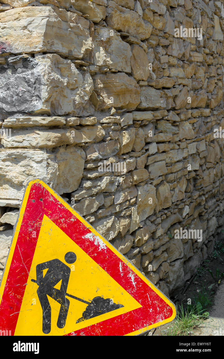 Road sign of work in progress against a wall in brick, rustic style ...