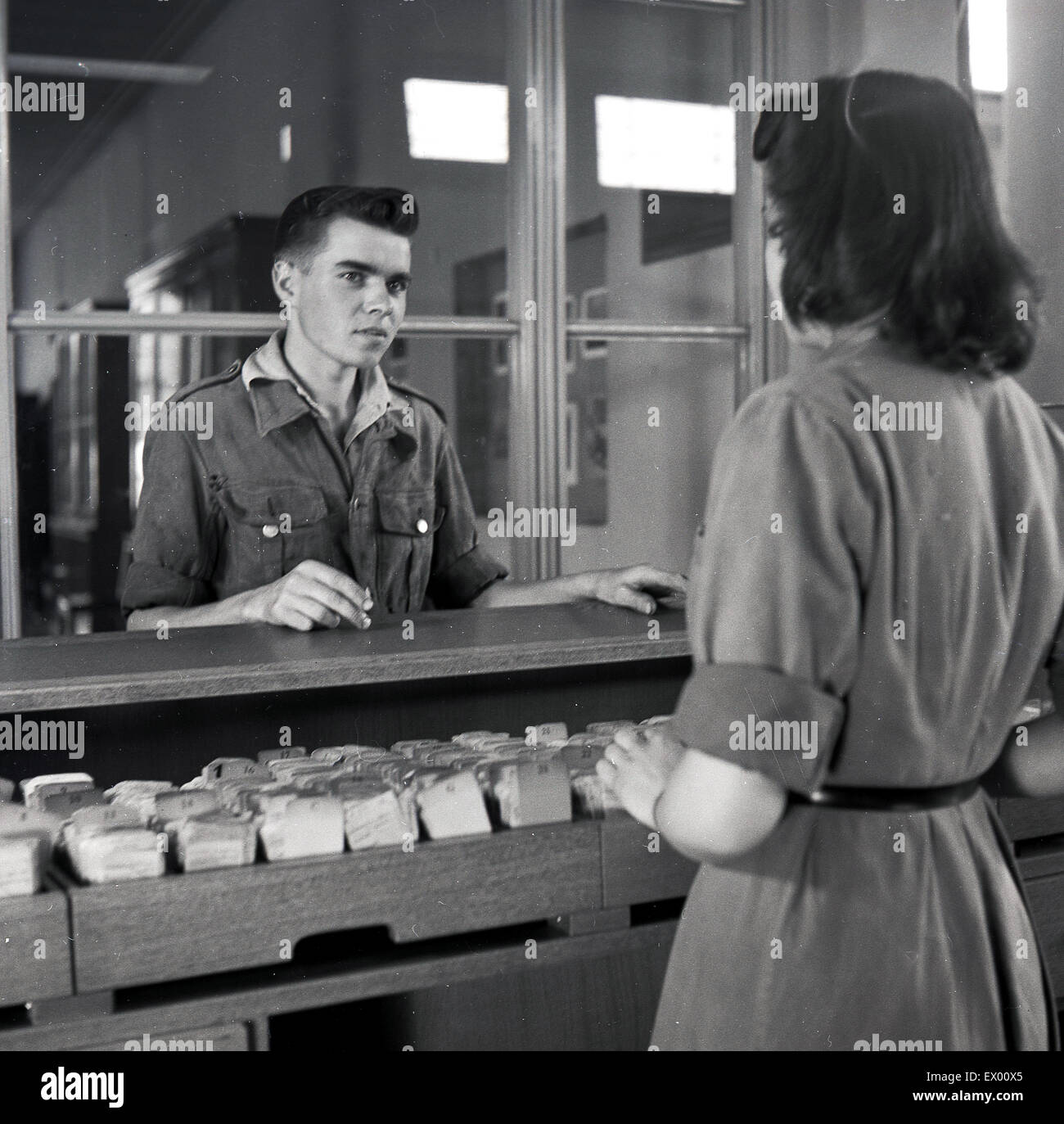 Historical, 1950s, young female librarian at counter in a library about ...