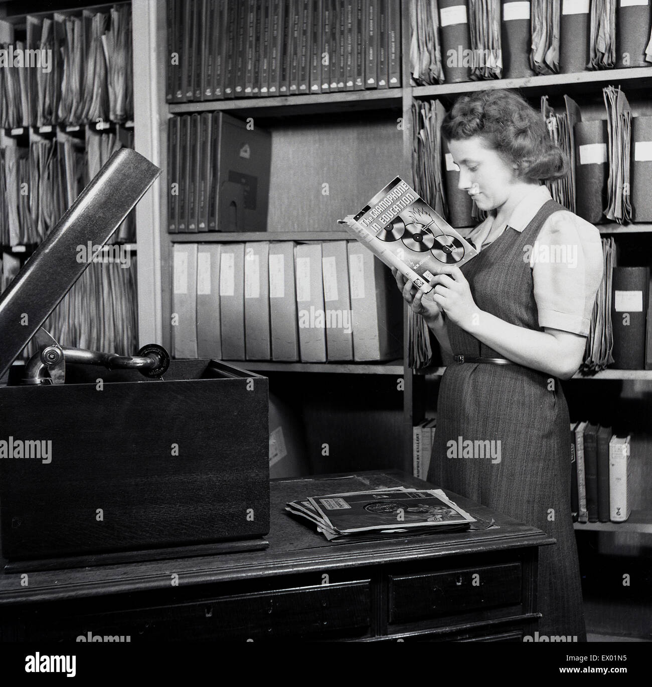 Historical, 1950s, young lady in library studying a catalogue and ...