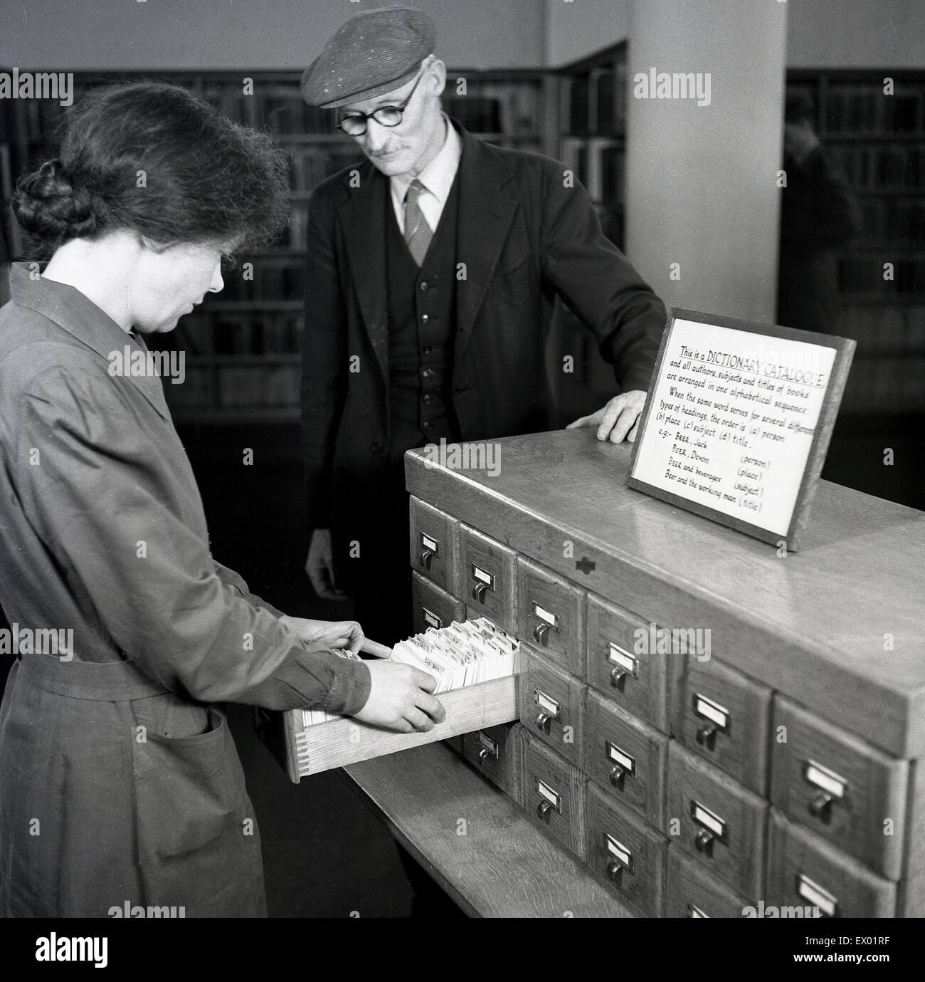 Historical, 1950s, young female librarian looking in the card index ...