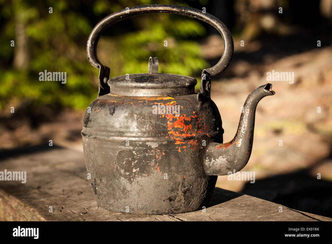 Old kettle in wooden bench outdoors Stock Photo - Alamy
