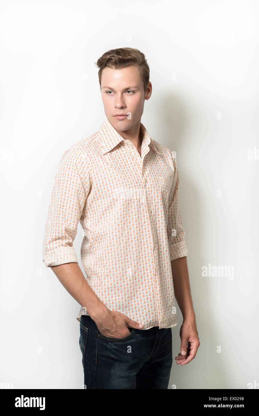 A handsome man, male model posing with his hand in pocket, looking away ...