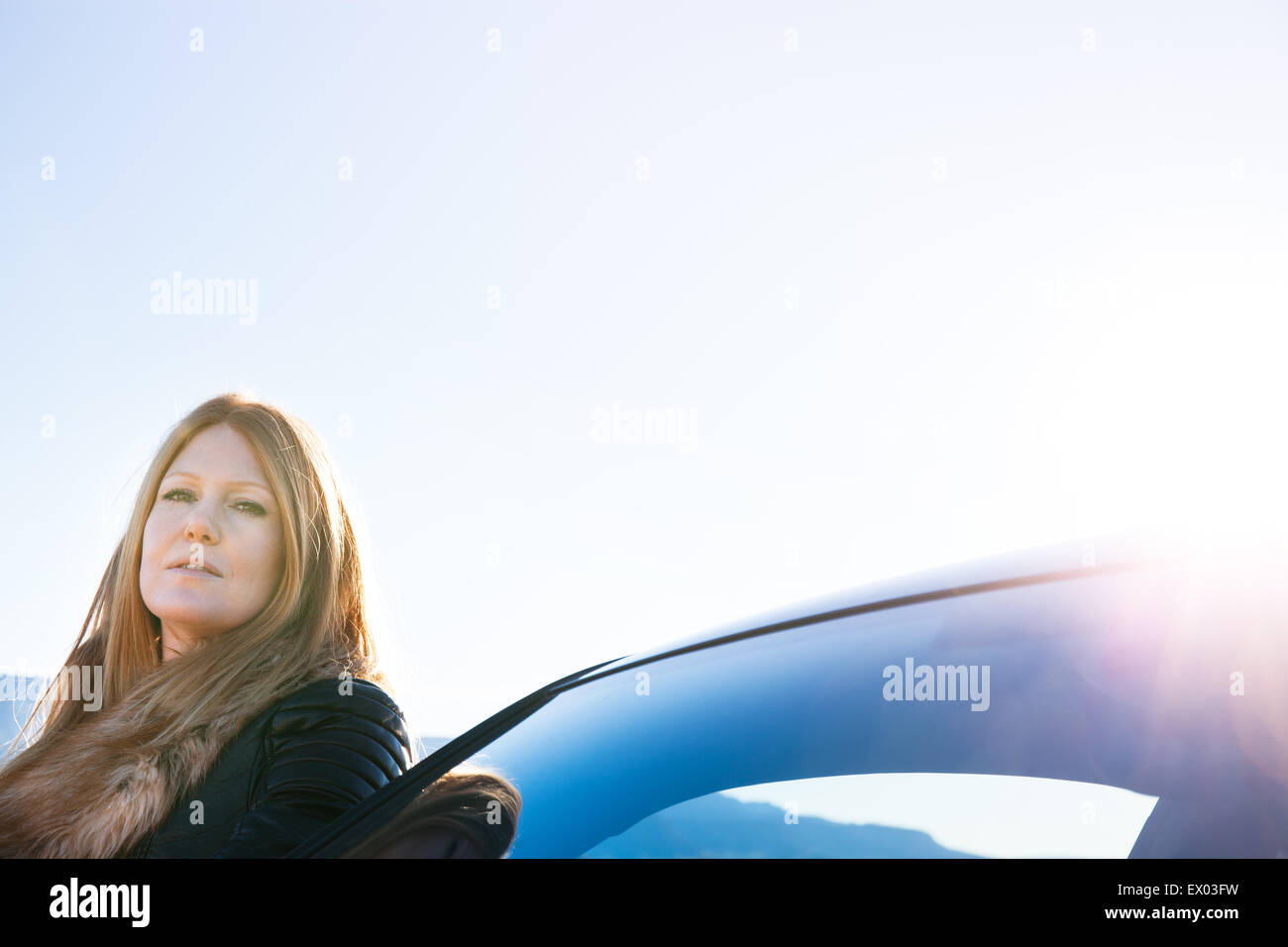 Woman leaning on car Stock Photo - Alamy