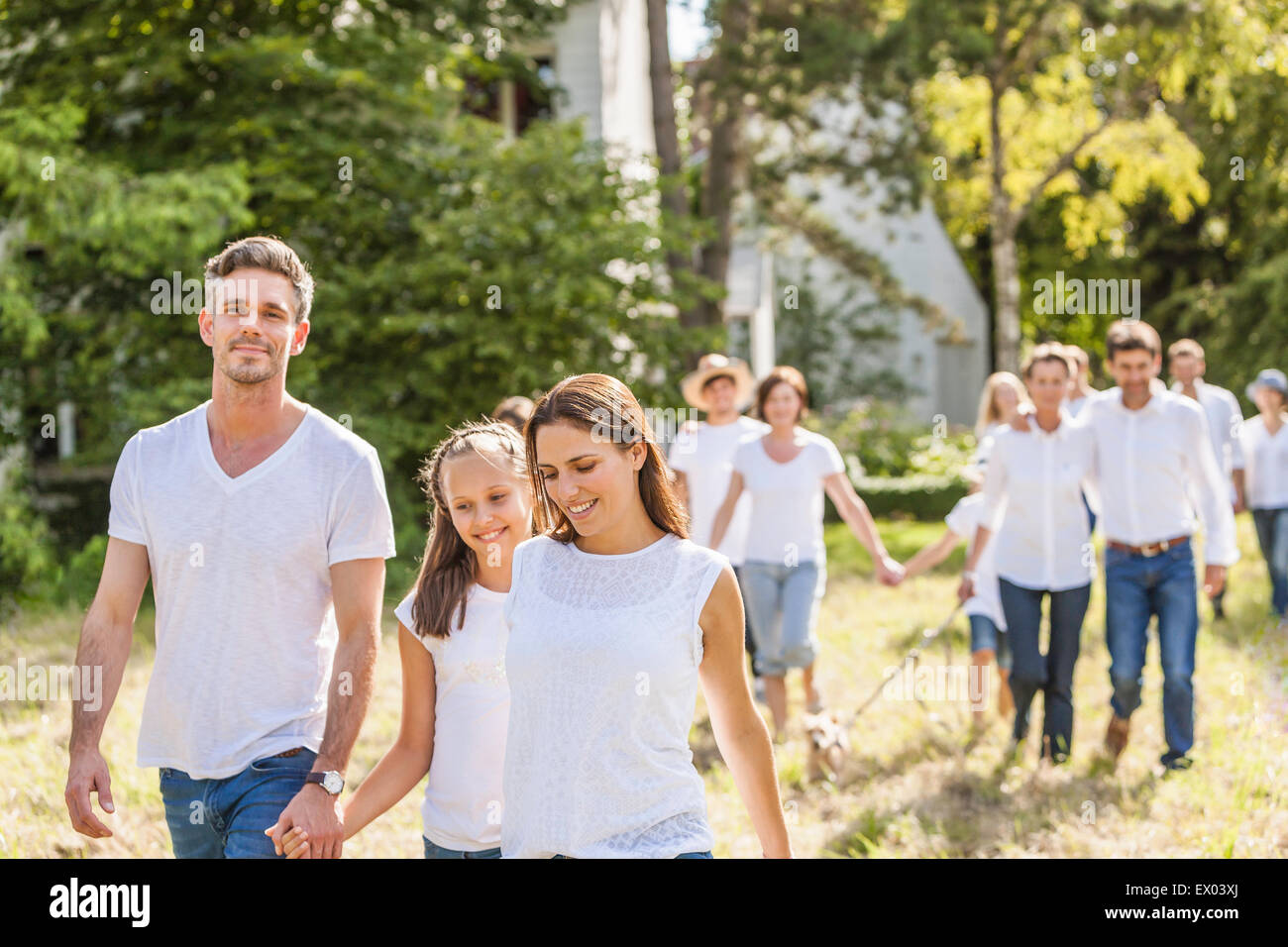 Group of people walking through forest Stock Photo - Alamy