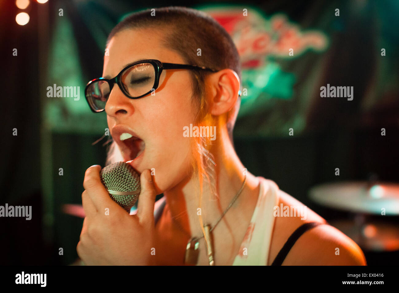 Punk girl singing into microphone Stock Photo - Alamy