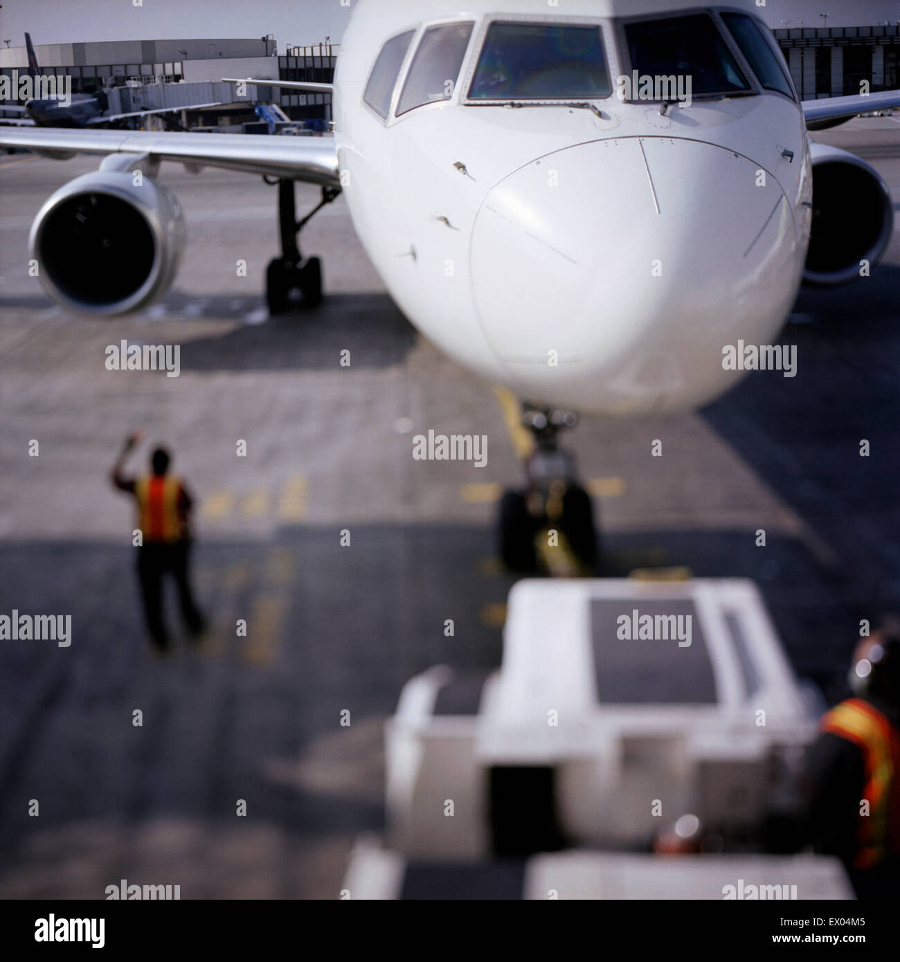 Airport worker guiding airplane on tarmac at JFK Airport, New York, USA ...