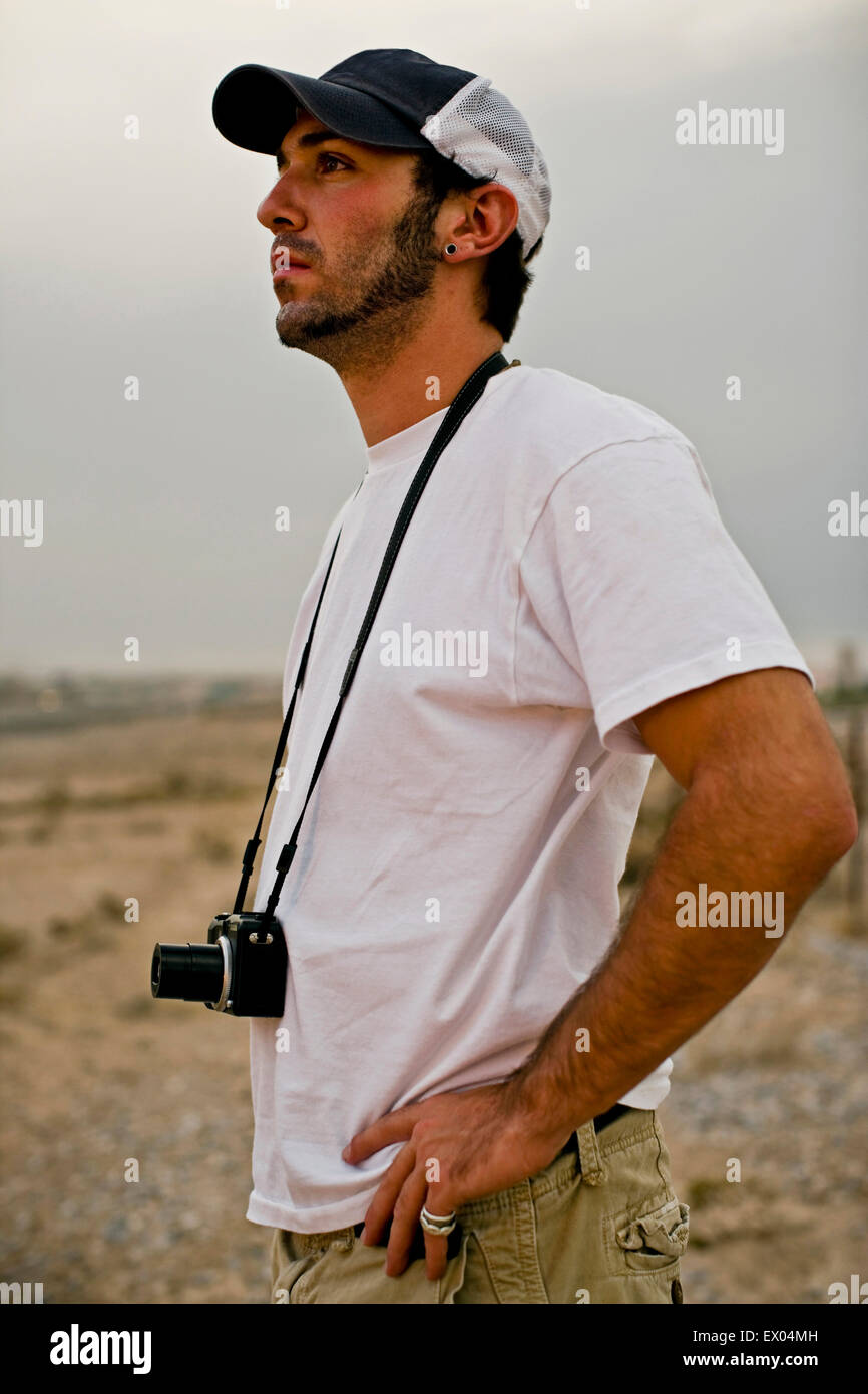 Man with digital camera looking out at desert storm clouds, Las Vegas ...