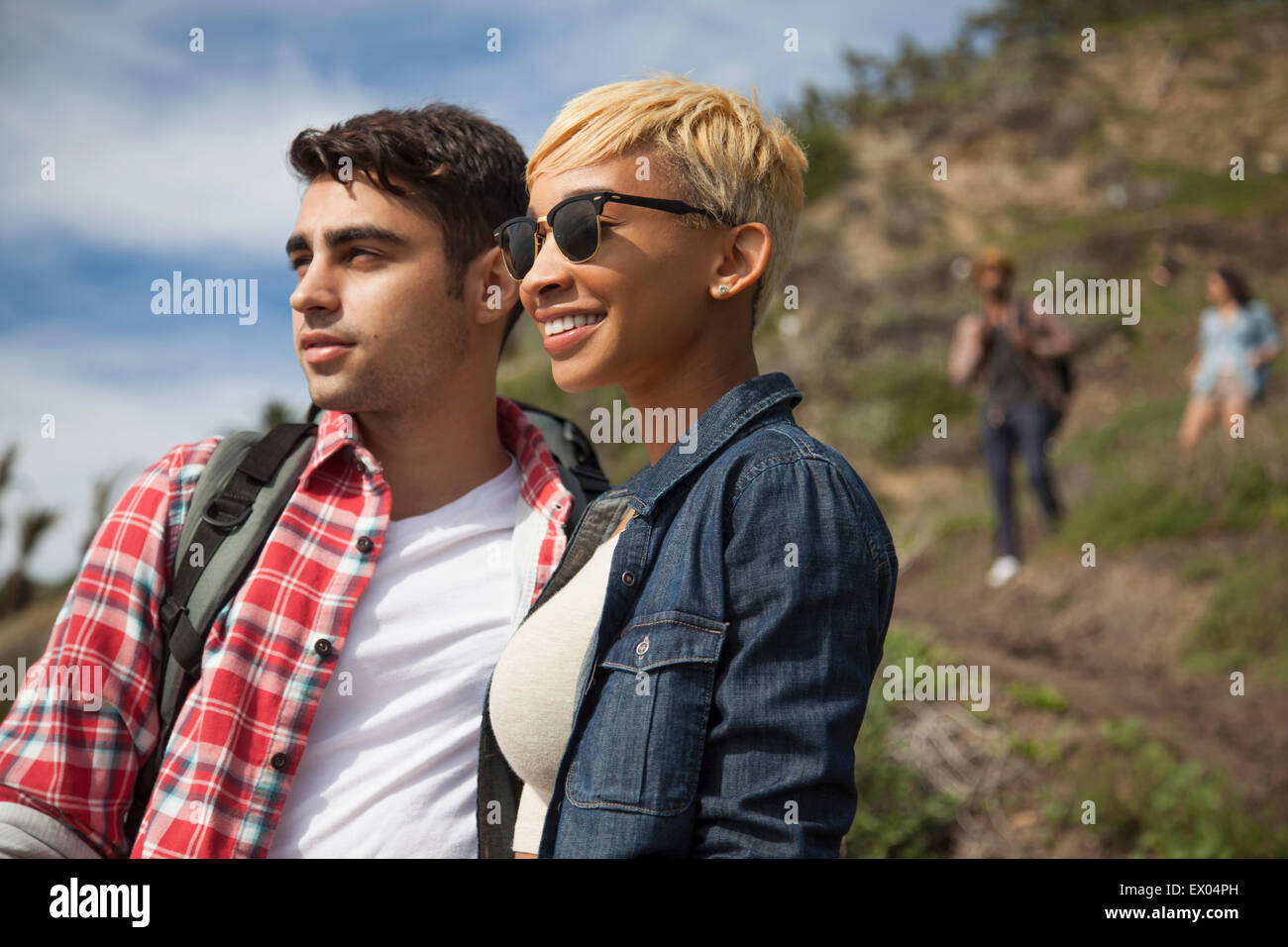 Young couple, outdoors, looking at view, friends trailing behind Stock ...