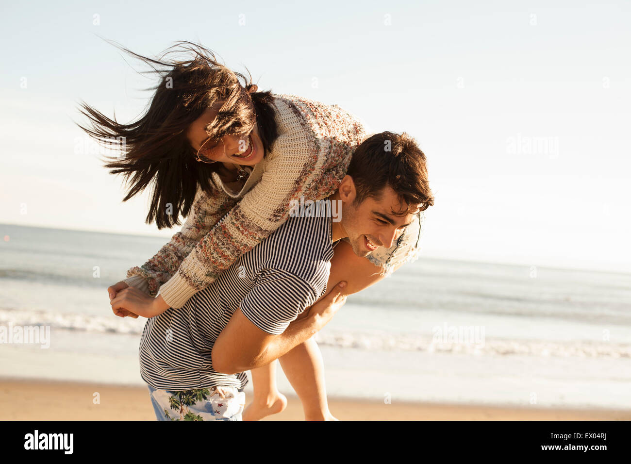 Young couple fooling around on beach Stock Photo - Alamy
