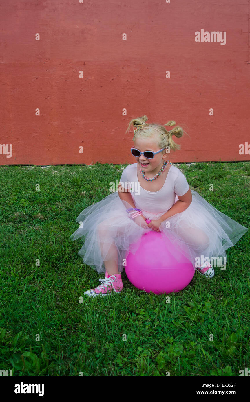 Young girl wearing tutu, bouncing on pink inflatable hopper Stock Photo ...