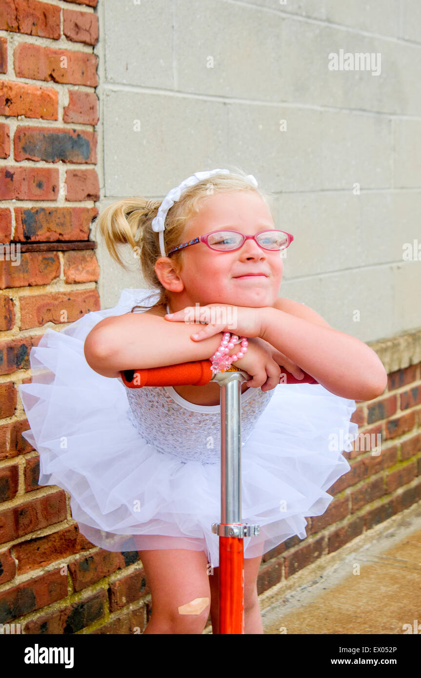 Portrait of young girl wearing tutu leaning on scooter handle Stock ...