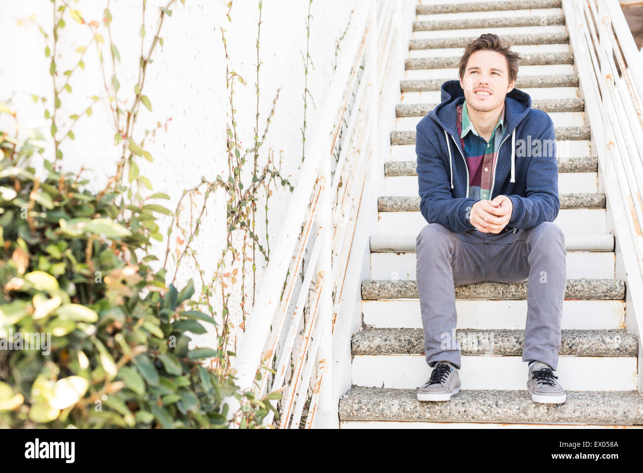 Young man sitting on steps Stock Photo - Alamy