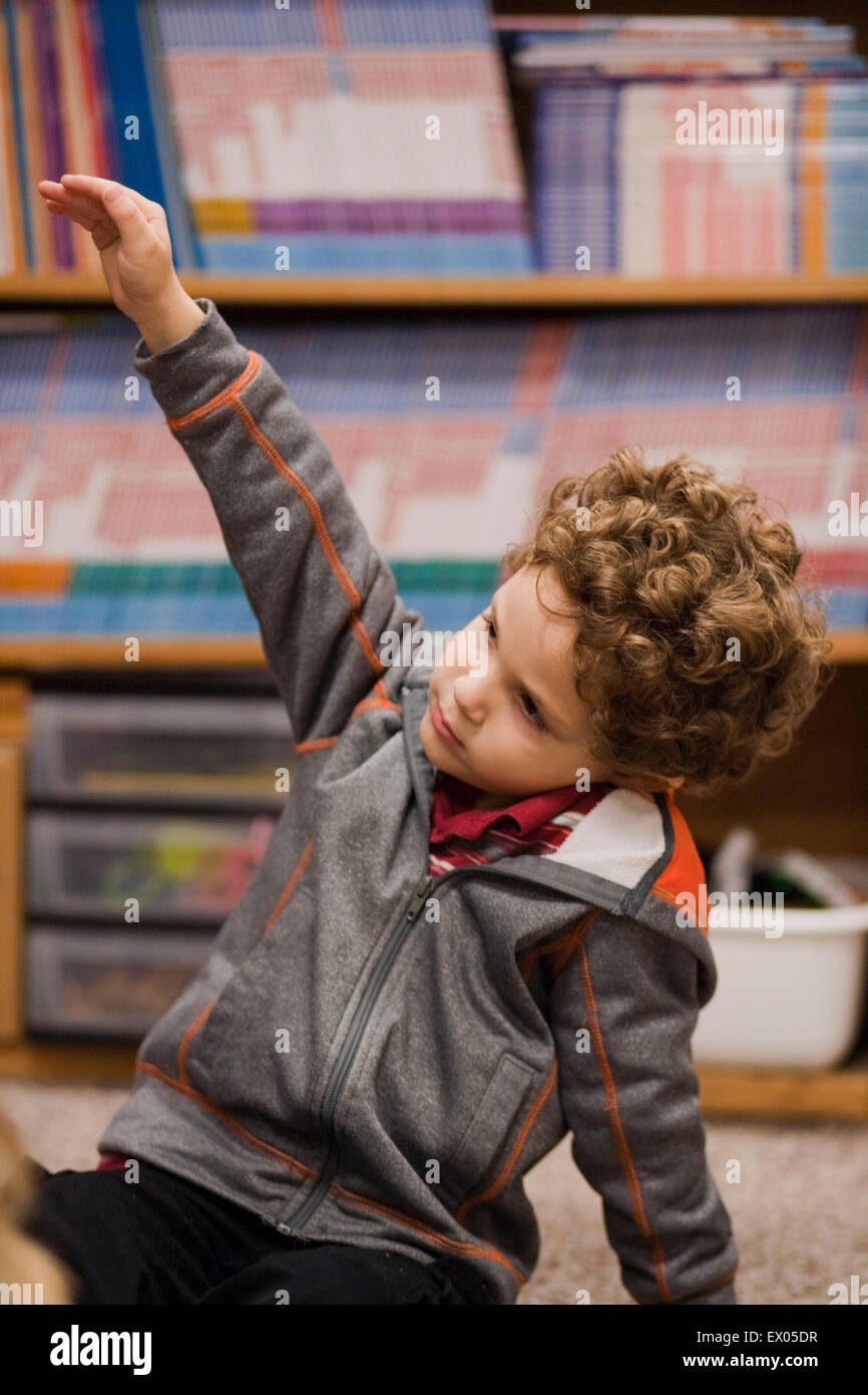 Boy raising hand in classroom hi-res stock photography and images - Alamy