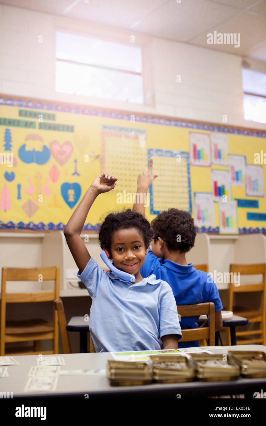 Pupils raising hands in classroom Stock Photo - Alamy