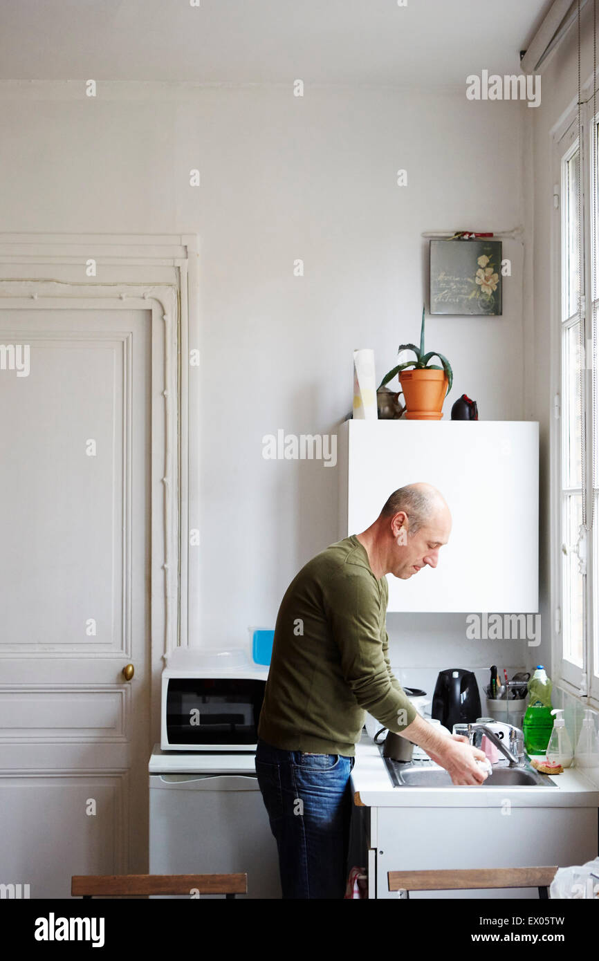 Mature man washing up in kitchen Stock Photo - Alamy