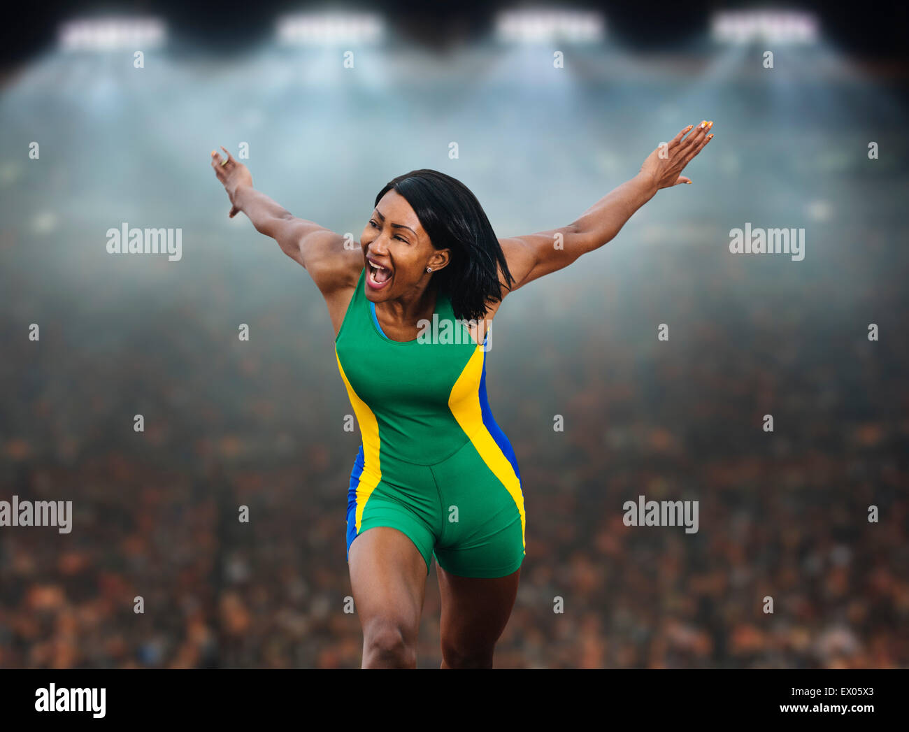 Young female athlete celebrating in front of stadium crowd Stock Photo ...