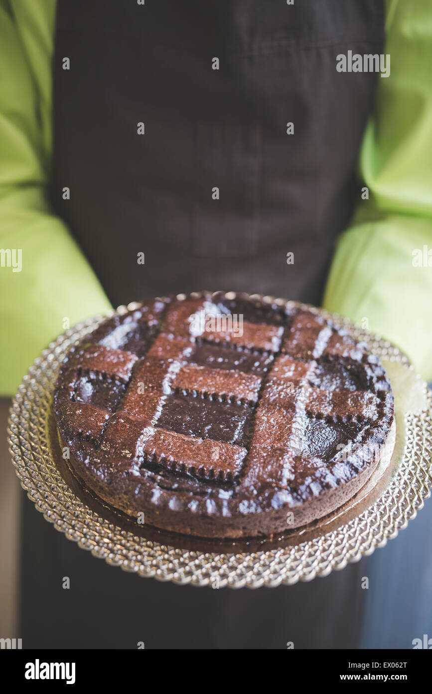Waiter carrying plate of chocolate cake Stock Photo - Alamy