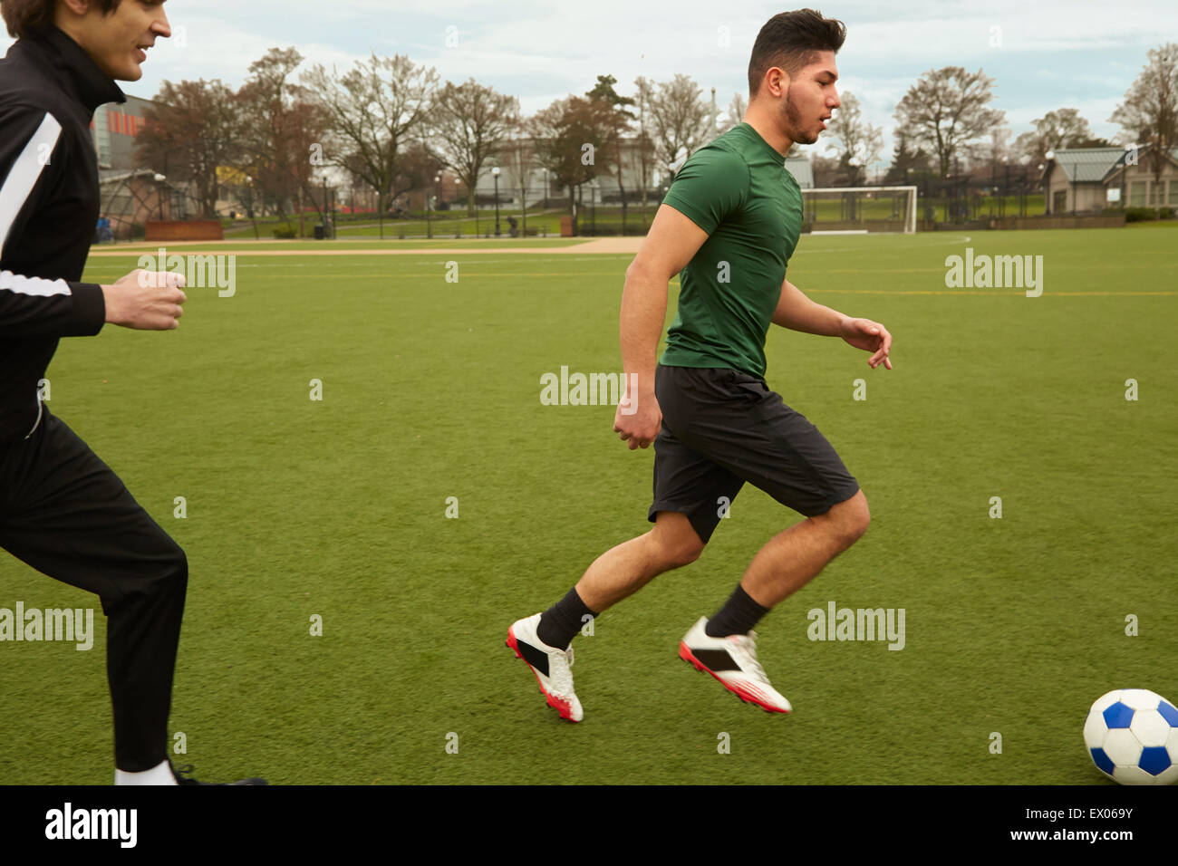 Mixed race man kicking soccer ball hi-res stock photography and images ...