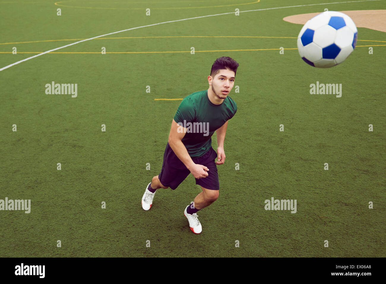 Young man playing soccer on football pitch Stock Photo - Alamy