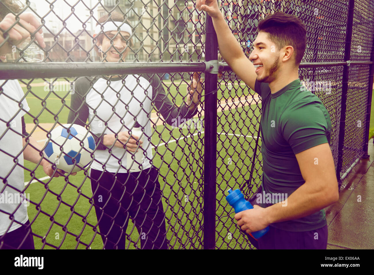 Three male soccer players chatting through wire fence Stock Photo - Alamy