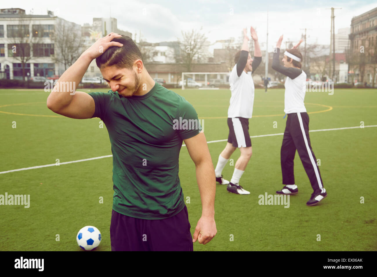 Disappointed male soccer player with hand in hair on soccer pitch Stock ...