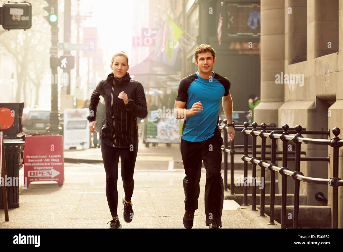 Young man and woman running along street, Pioneer Square, Seattle, USA ...