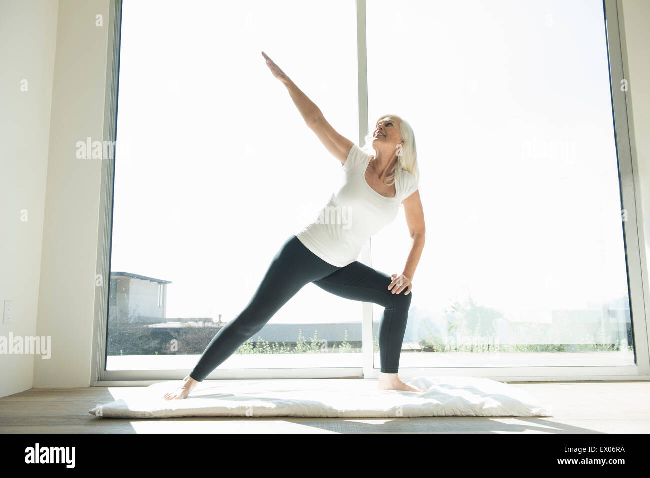 Senior woman in yoga pose, arm raised Stock Photo - Alamy
