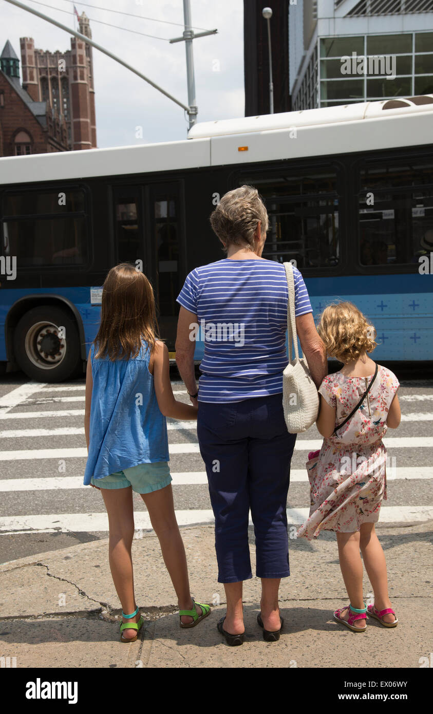 Woman with two young children waiting to cross the street New York USA ...