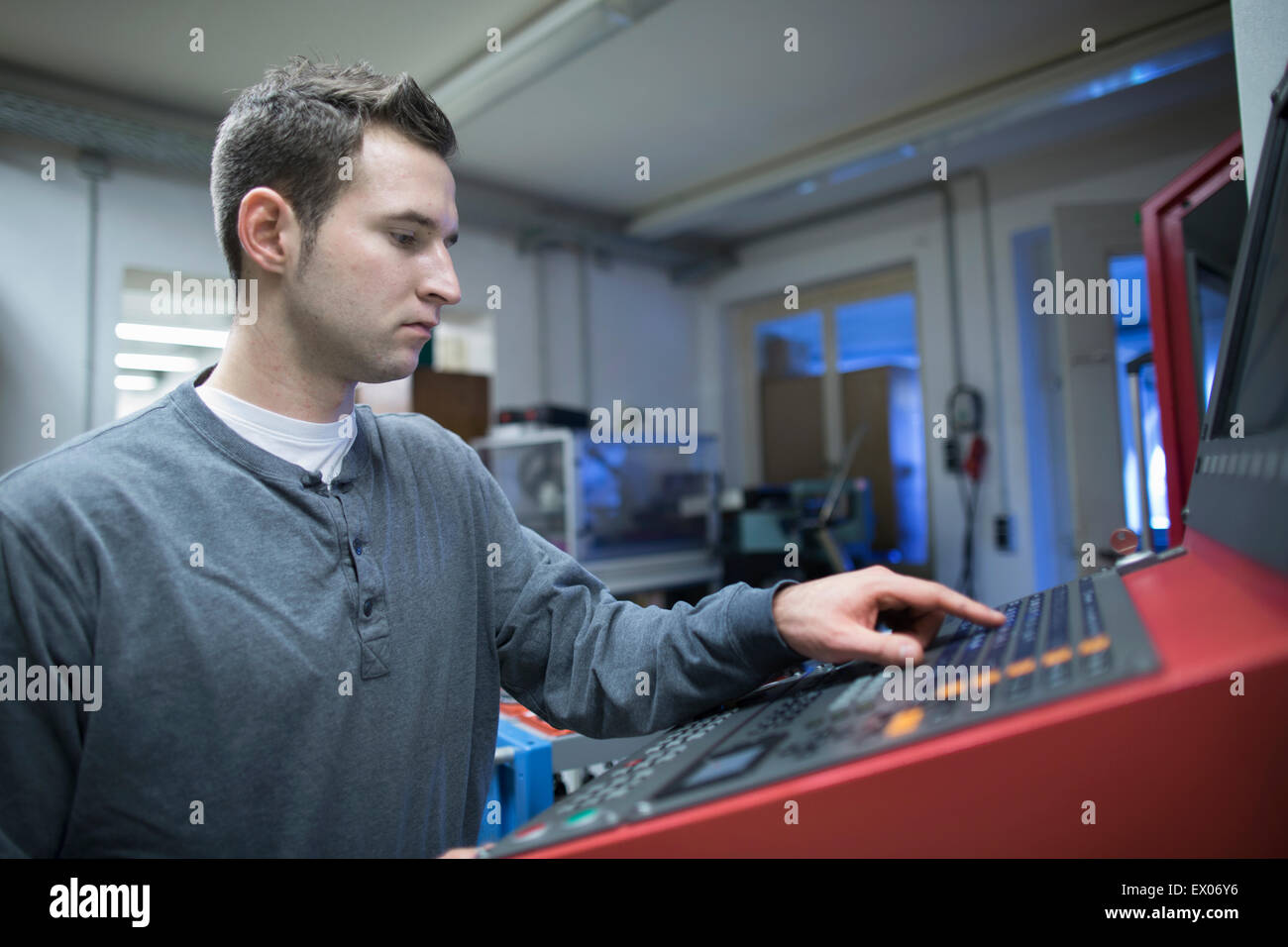 Young male technician using control panel for machine in workshop Stock ...
