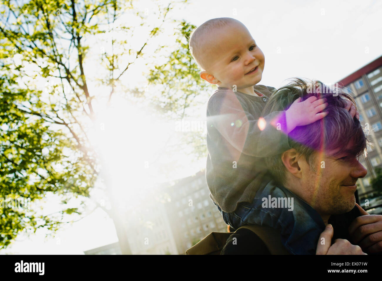 Father giving baby daughter shoulder ride whilst walking in city Stock ...