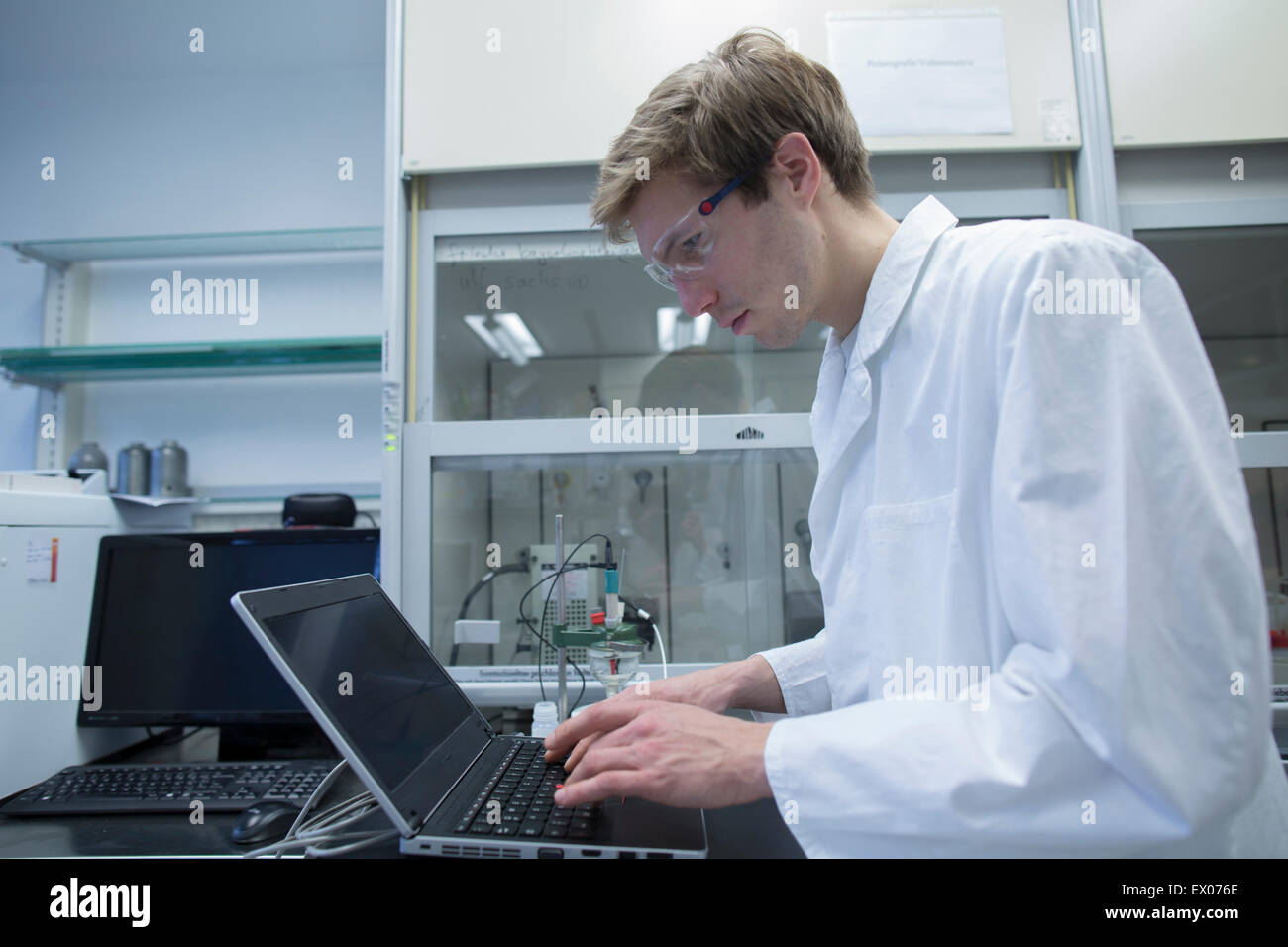 Male scientist typing on laptop in lab Stock Photo - Alamy