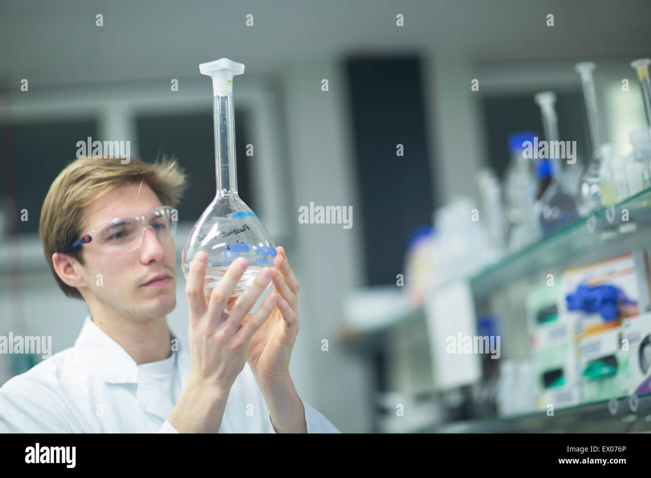Male scientist holding up flask in lab Stock Photo - Alamy