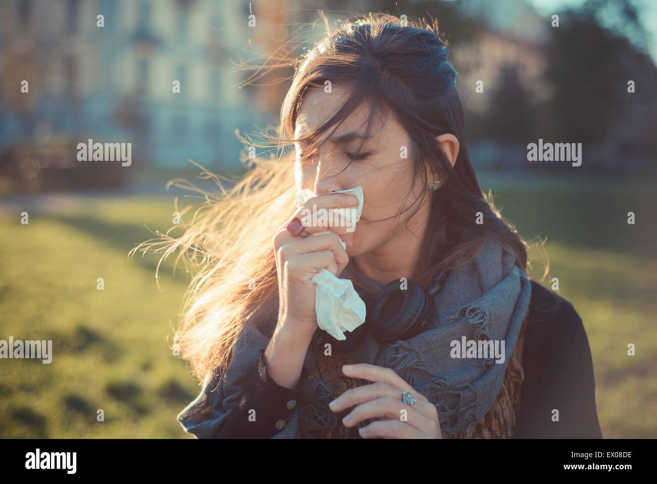 Mid adult woman blowing nose with handkerchief in park Stock Photo - Alamy
