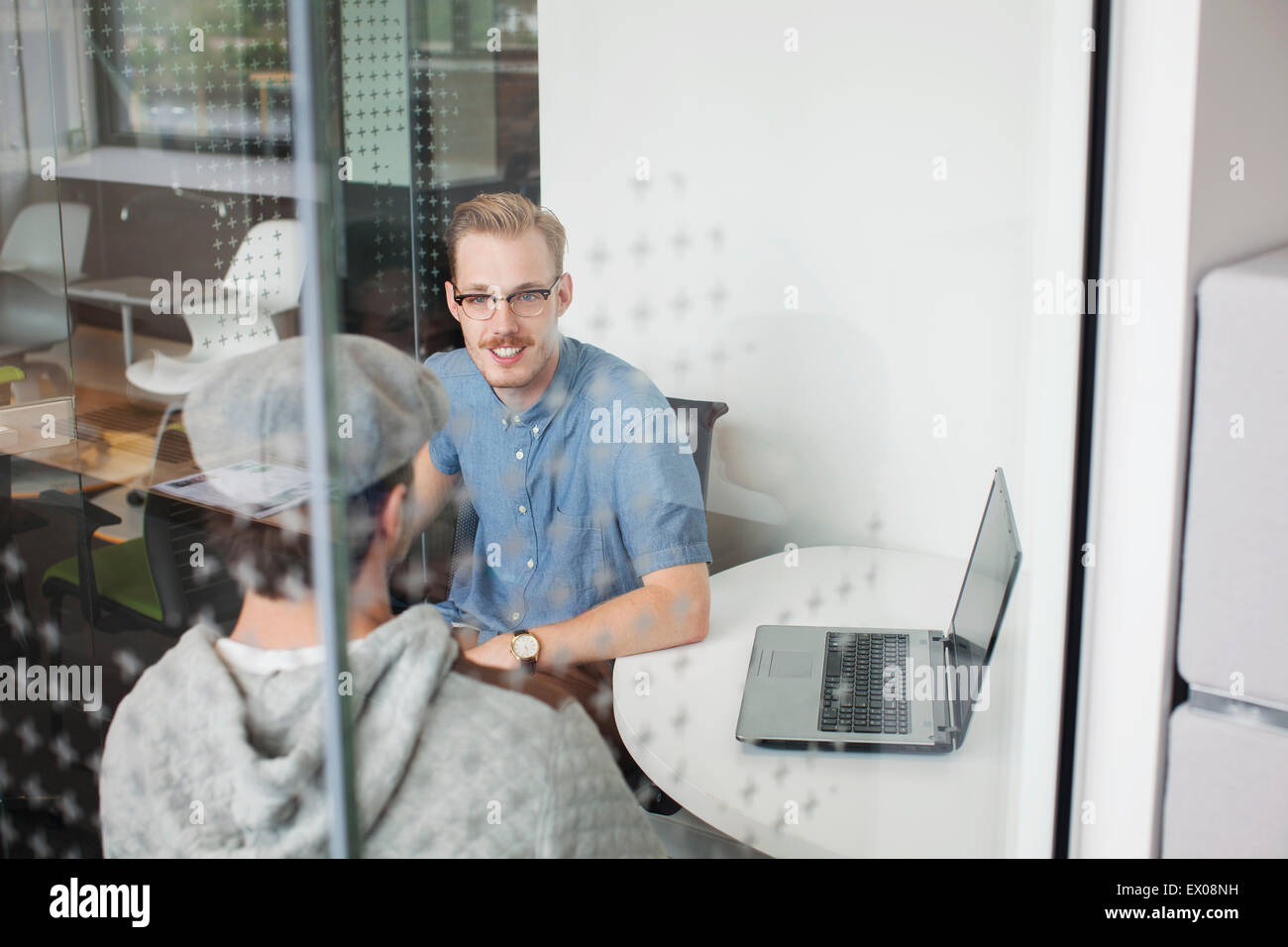 Colleagues having informal desk meeting Stock Photo - Alamy